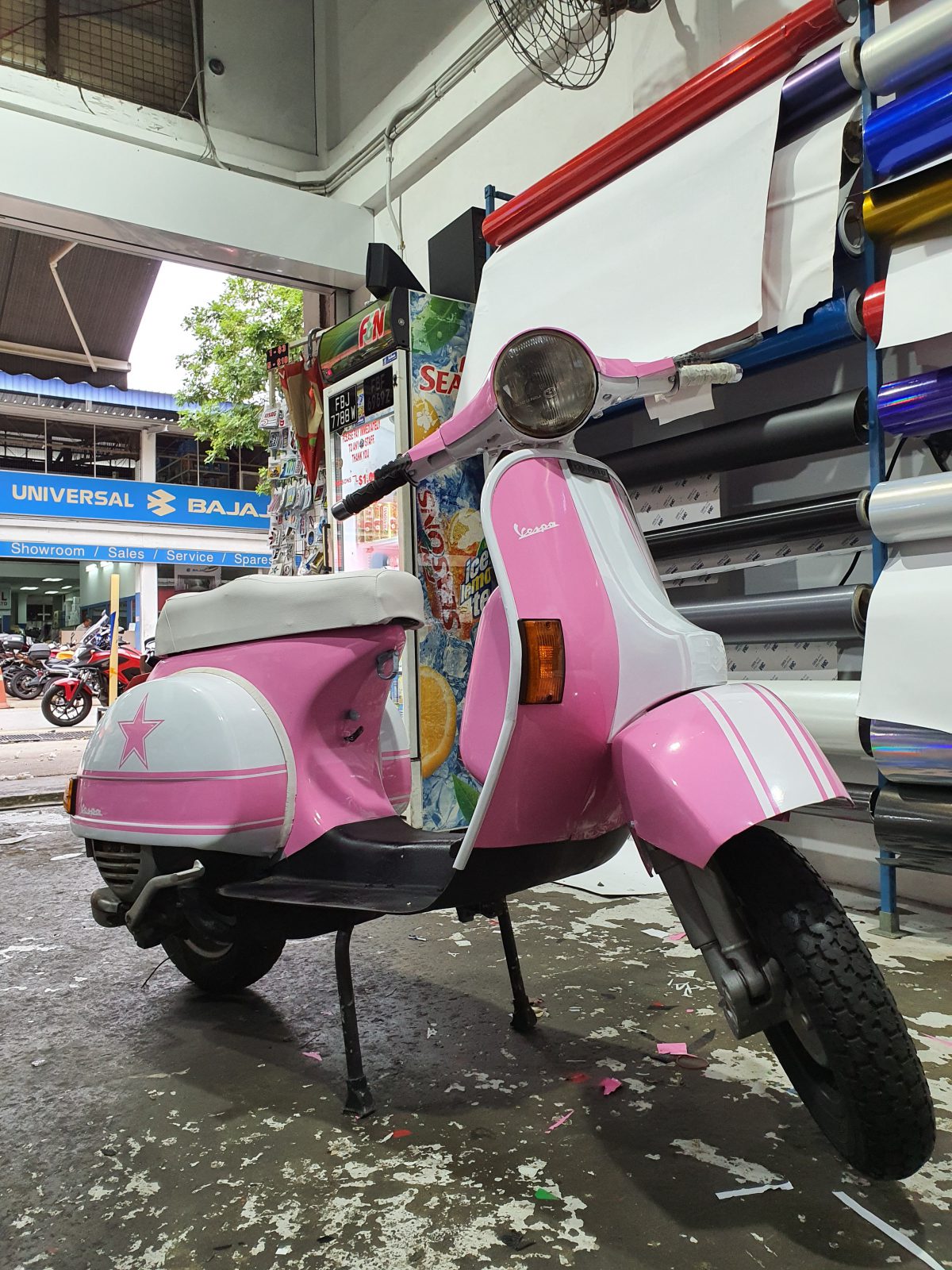 A Classic Vespa PX125 wrapped in soft pink with white stripes in decals